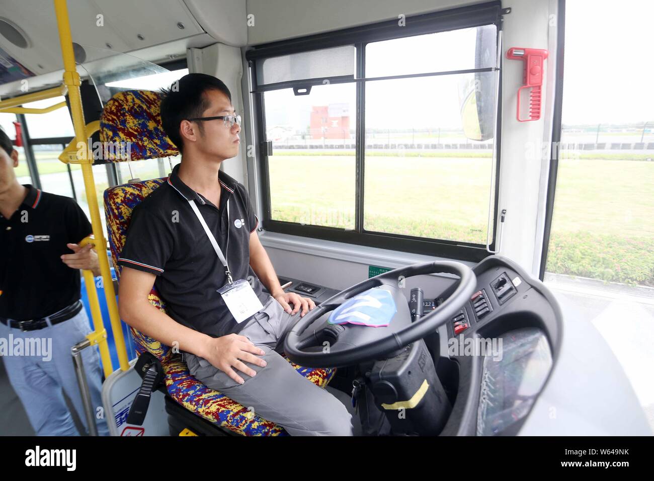 A Chinese employee sits on the driver's seat of a self-driving electric ...