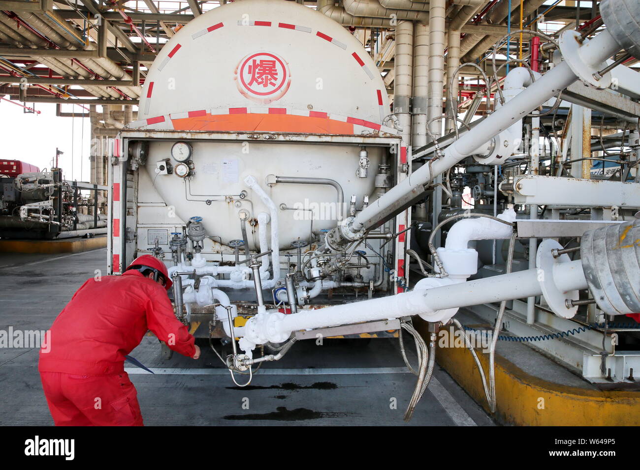 Chinese workers load a tanker with liquefied natural gas (LNG) at the ...