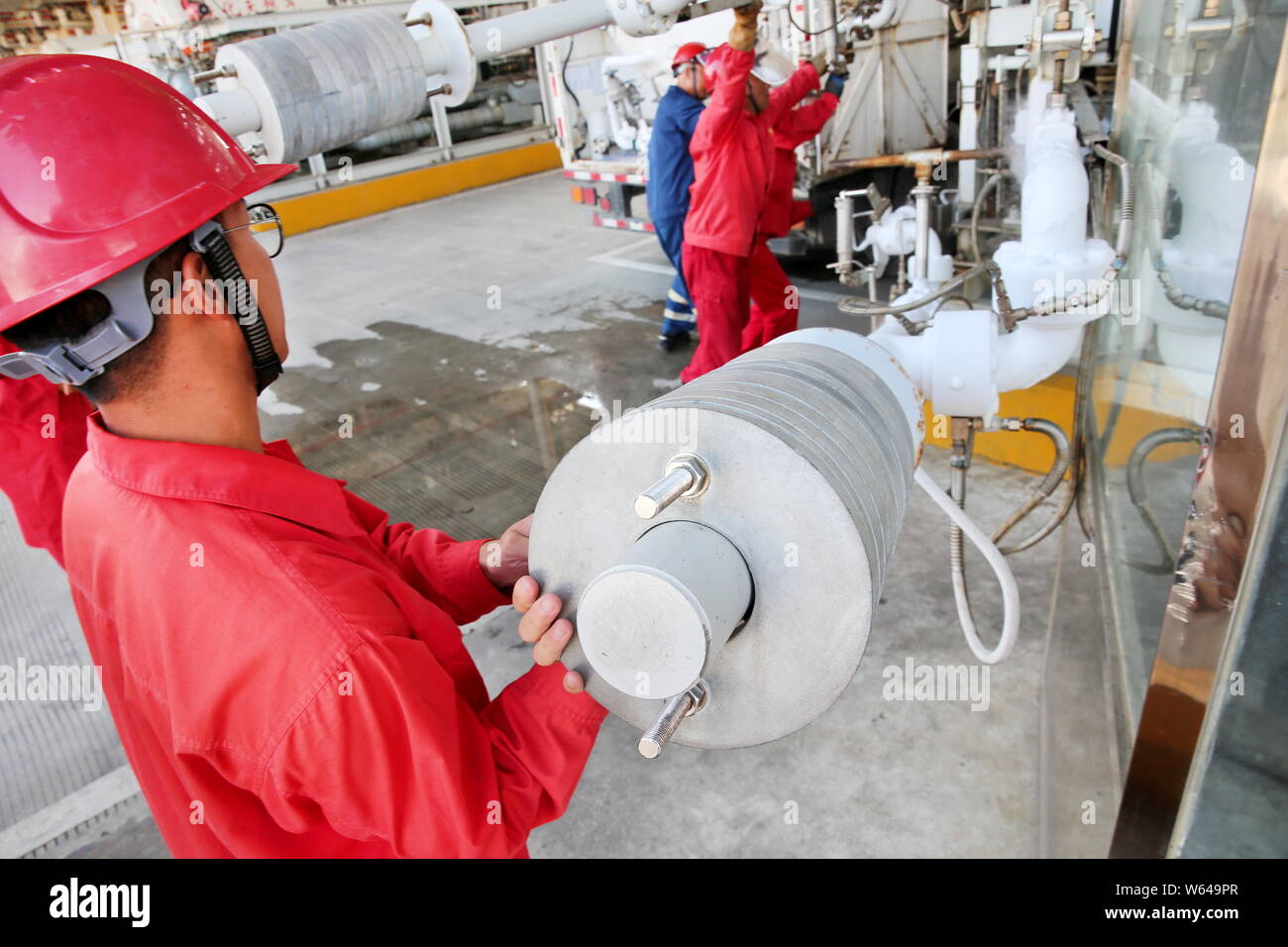 Chinese workers load a tanker with liquefied natural gas (LNG) at the ...