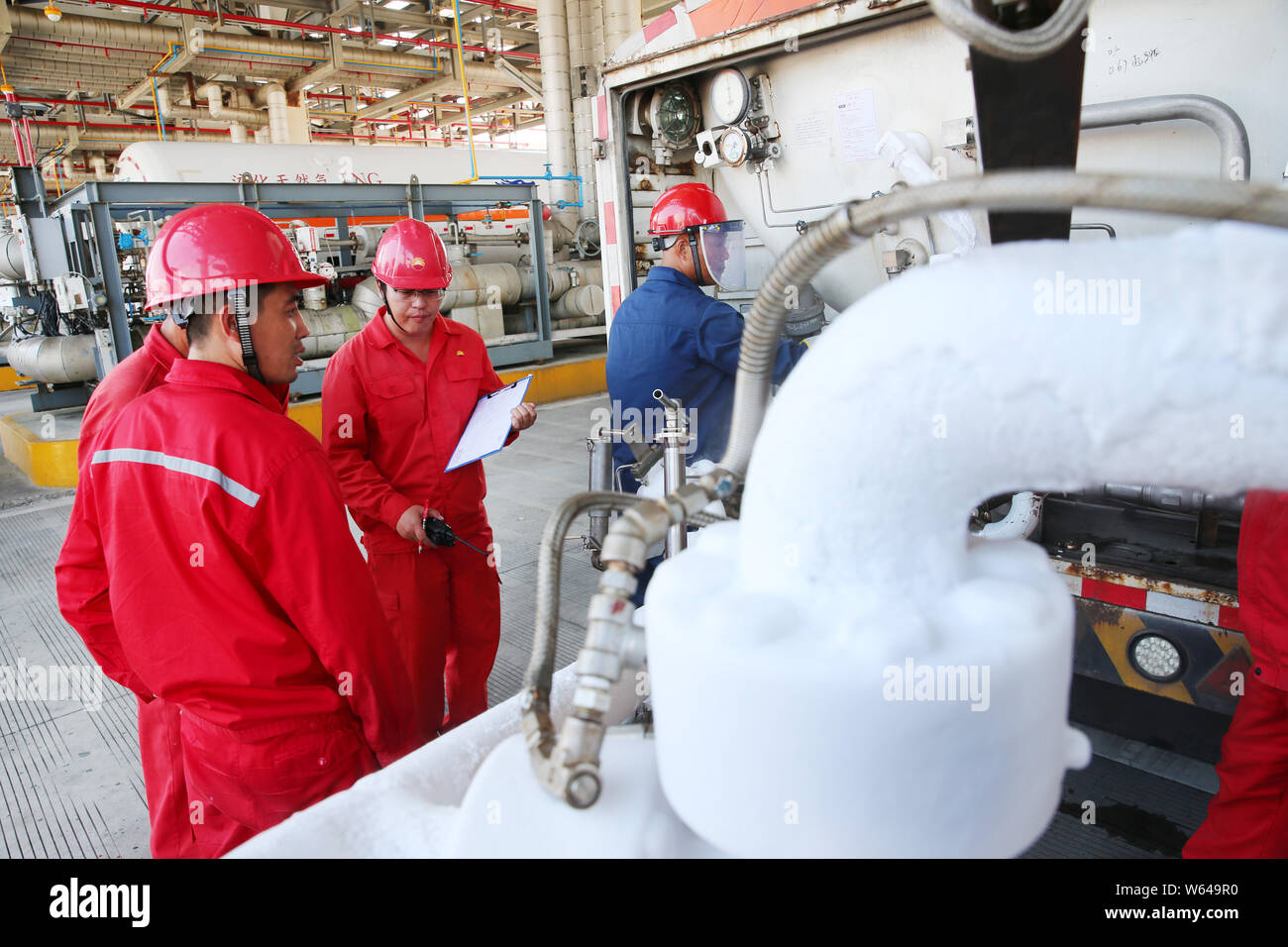 Chinese workers load a tanker with liquefied natural gas (LNG) at the ...