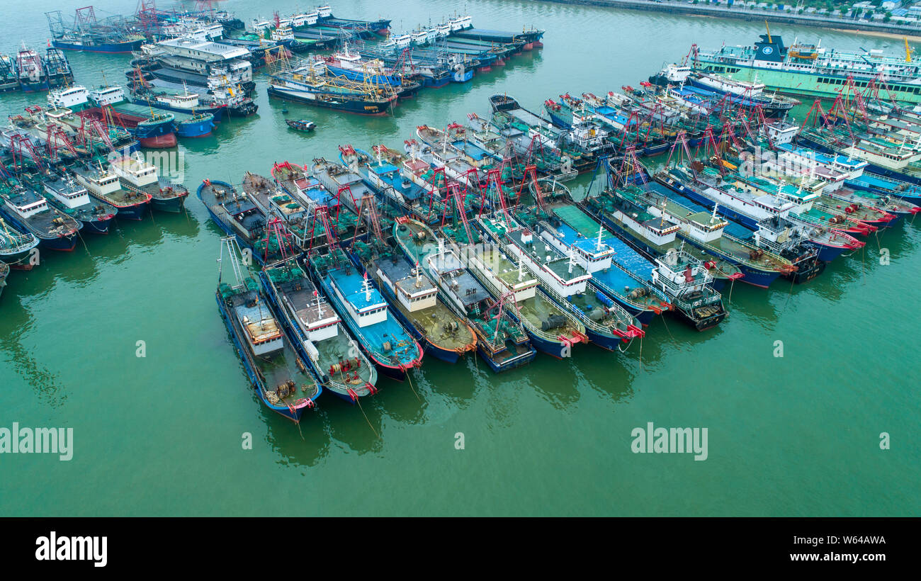 Fishing boats are docked at a harbor in preparation for Typhoon Barijat ...