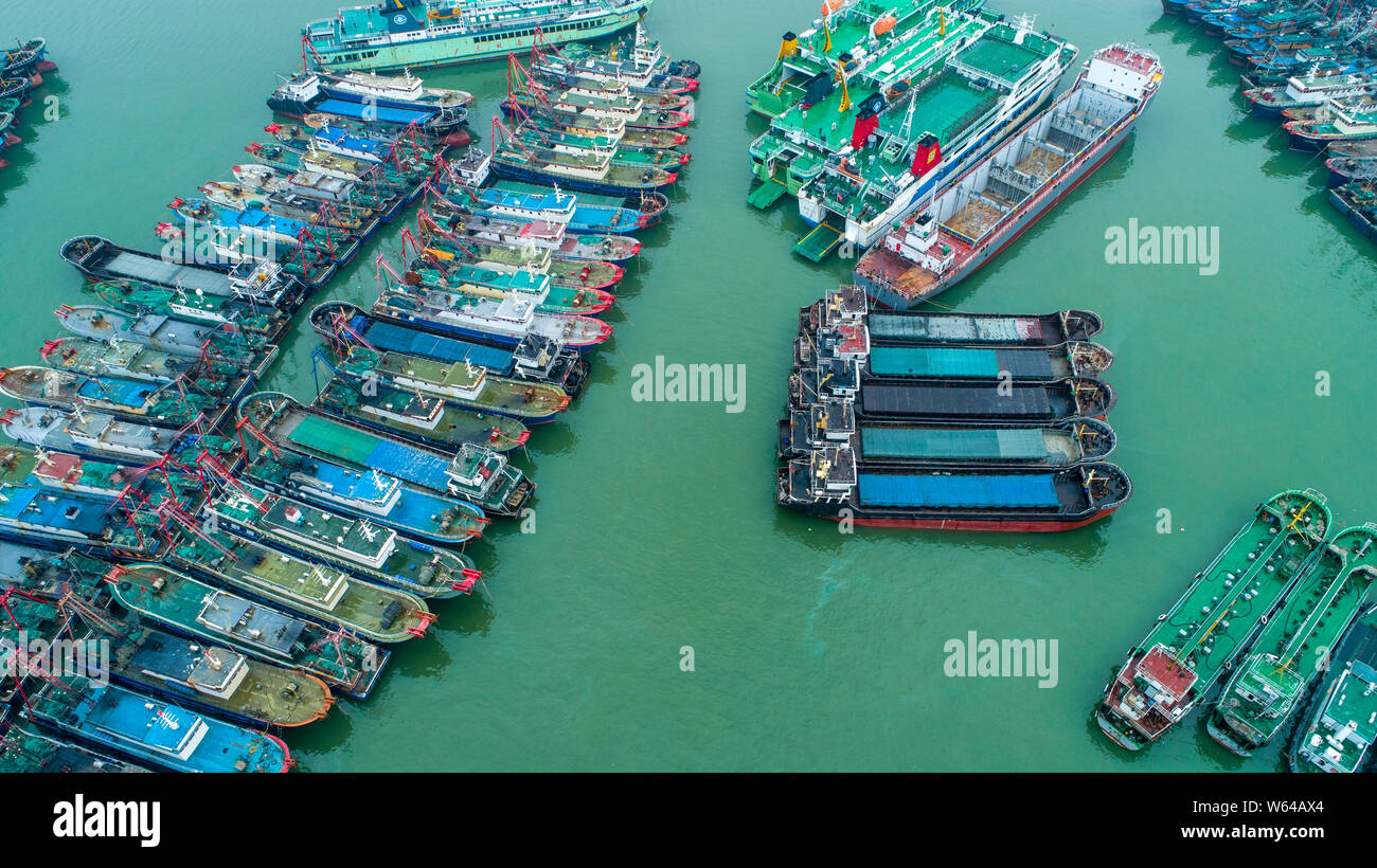 Fishing boats are docked at a harbor in preparation for Typhoon Barijat ...