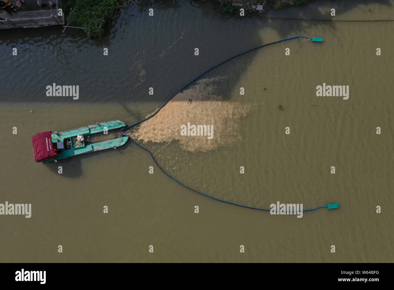 In this aerial view, a boat equipped with a new device collects garbage ...