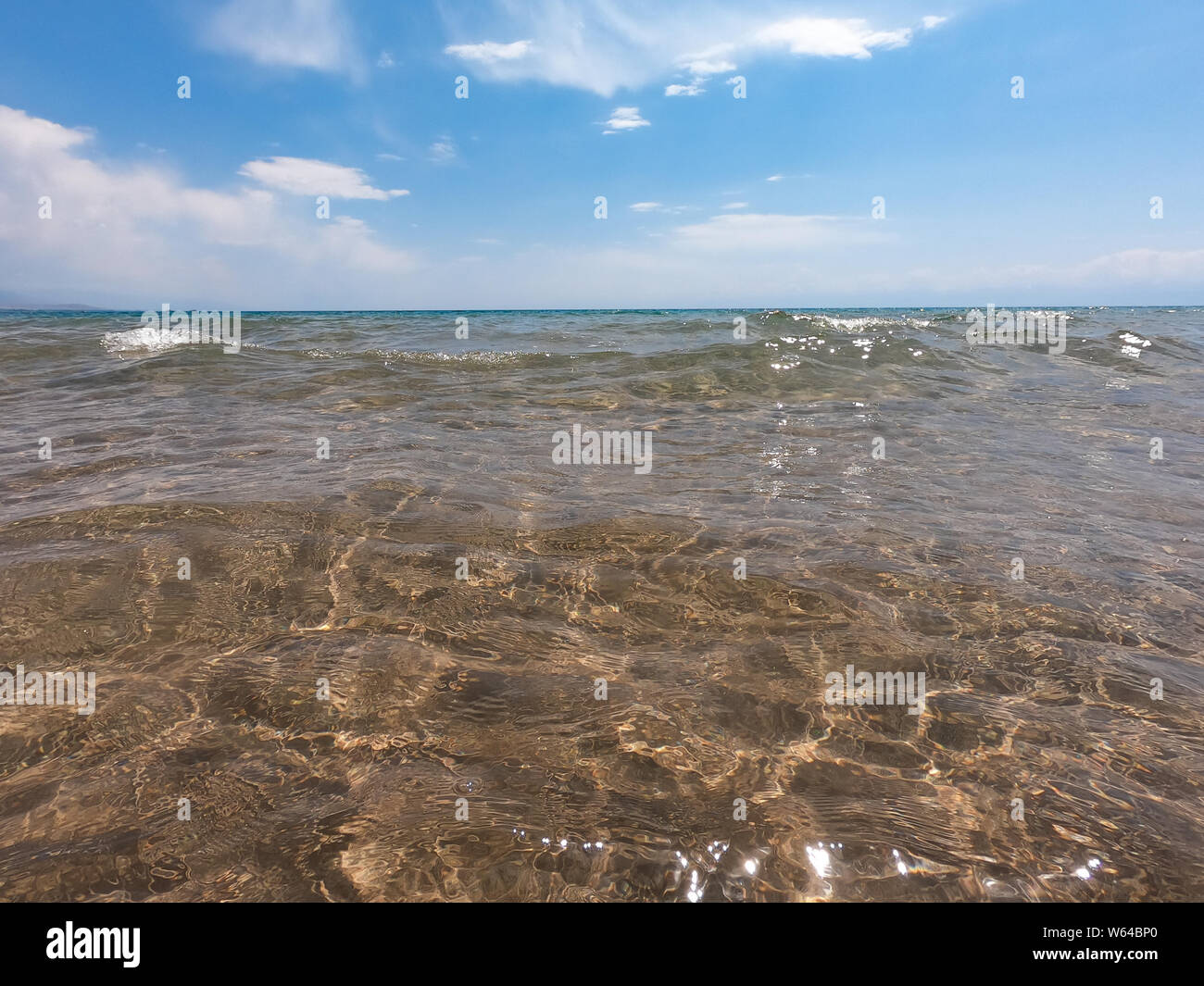 Sea shore. Blue transparent water and sand Stock Photo - Alamy