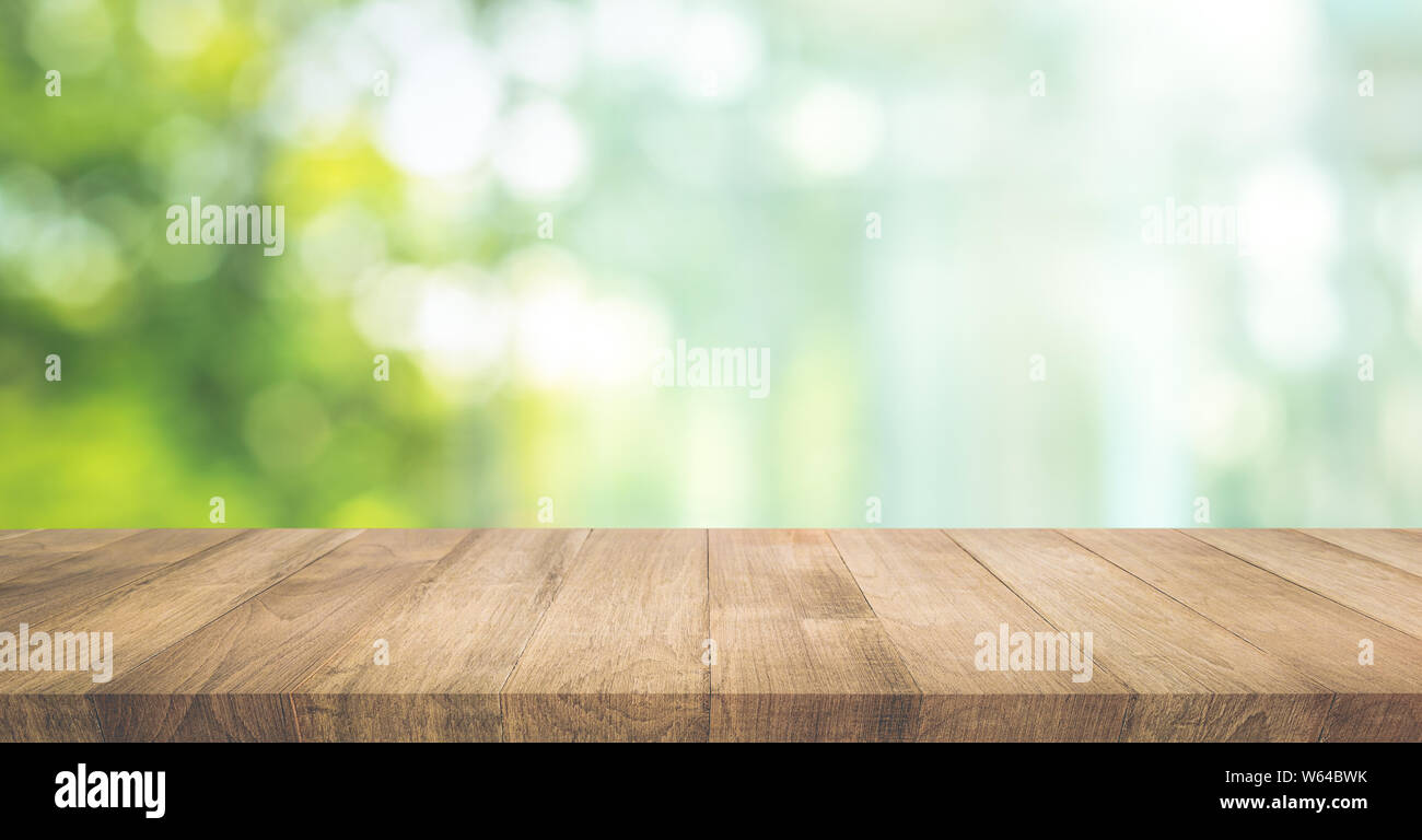 Real wood table top texture on blur leaf tree garden background.For ...