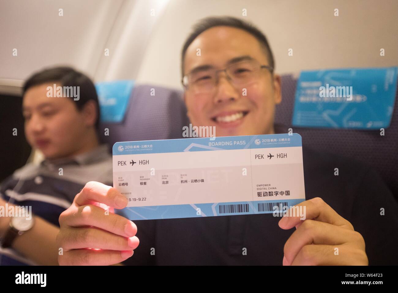 A Chinese passenger shows his boarding pass onboard Flight CZ6163 from ...