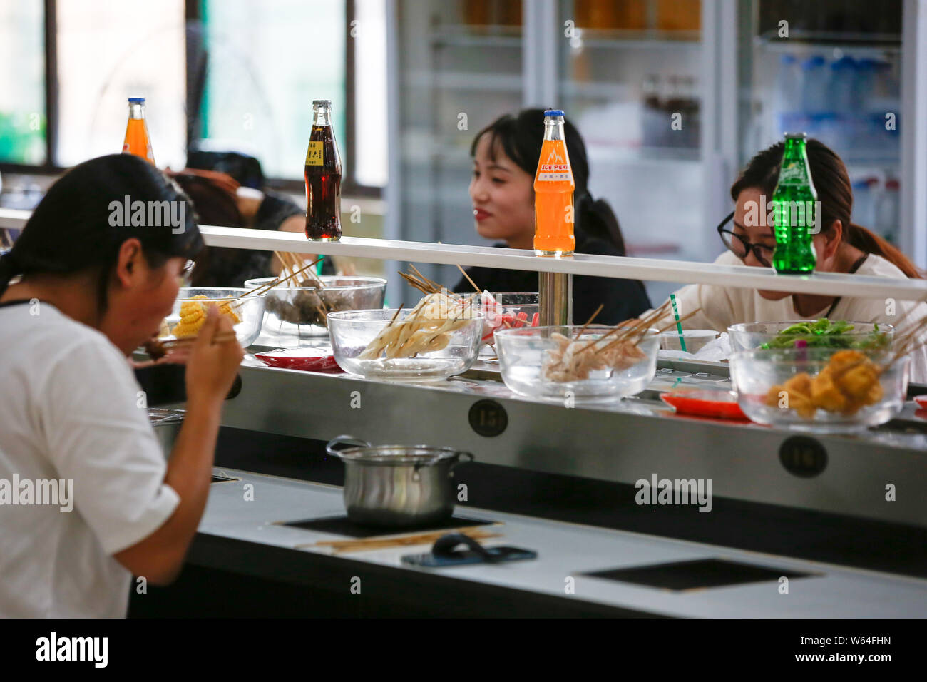 Students eat conveyor belt hotpot, literally "rotation hot pot," at a ...