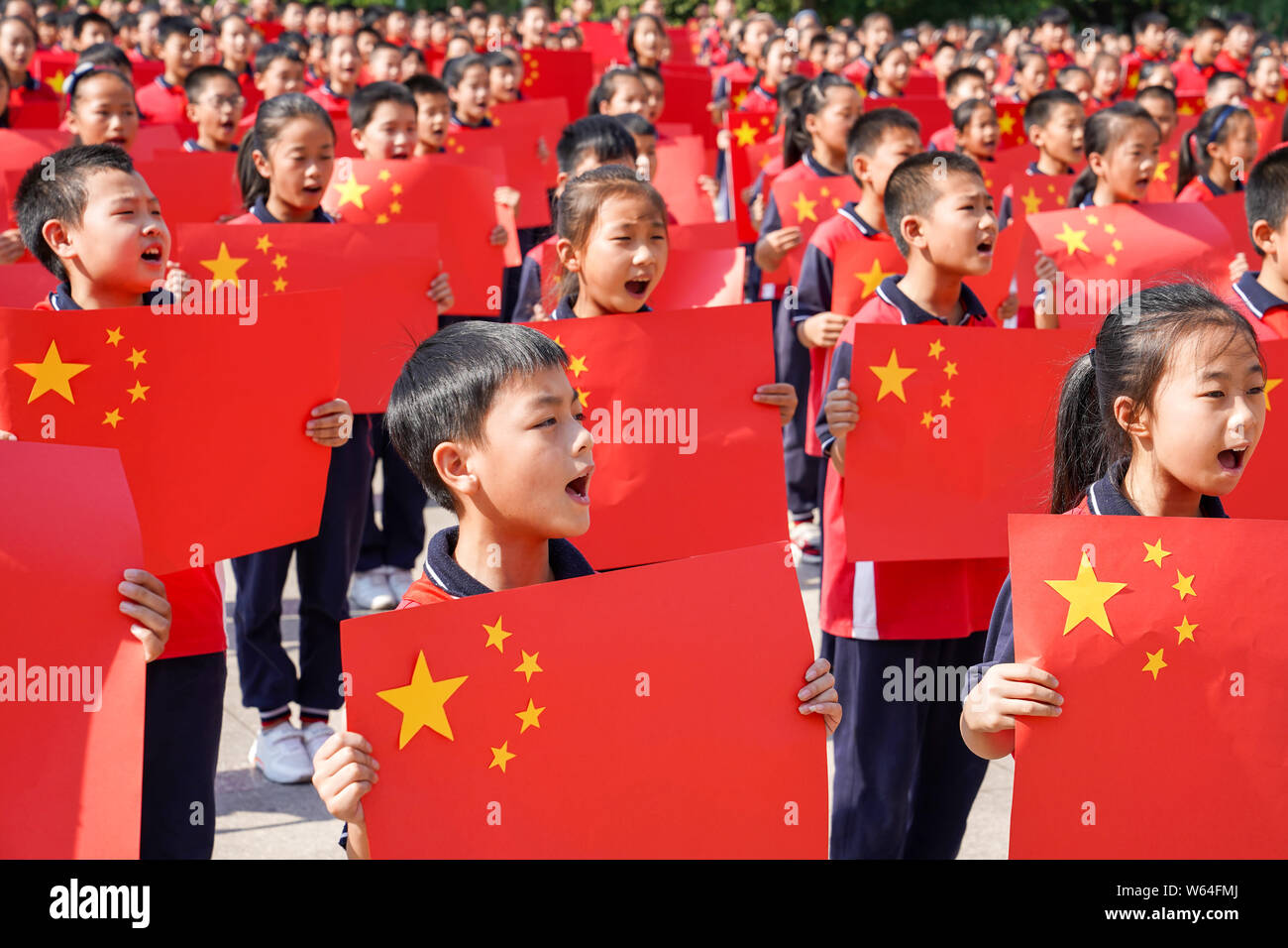Young Chinese students hold up national flags they made by themselves ...