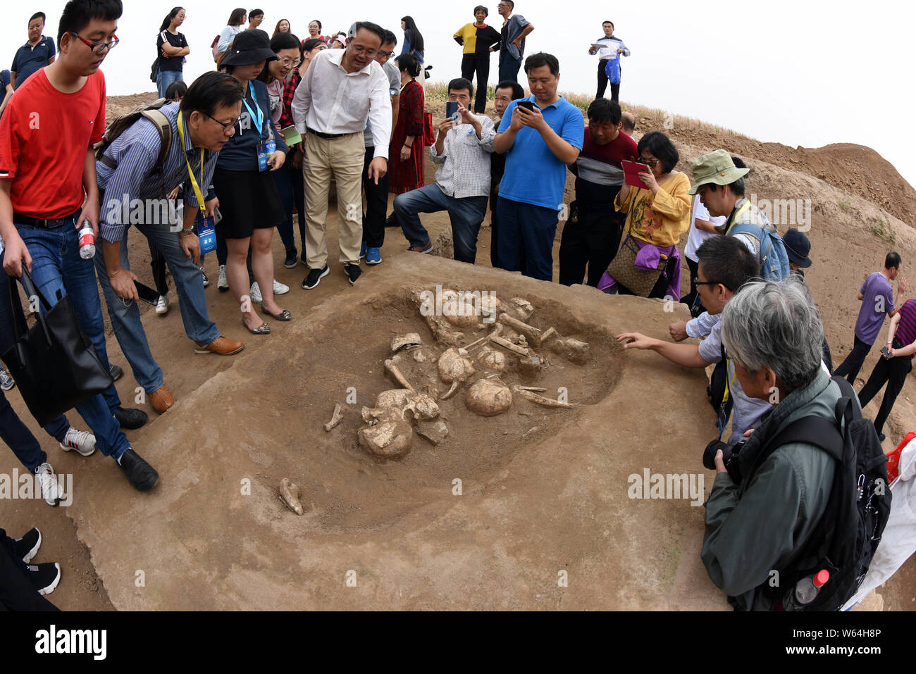 Visitors look at pottery unearthed in the excavation site of the ruins ...