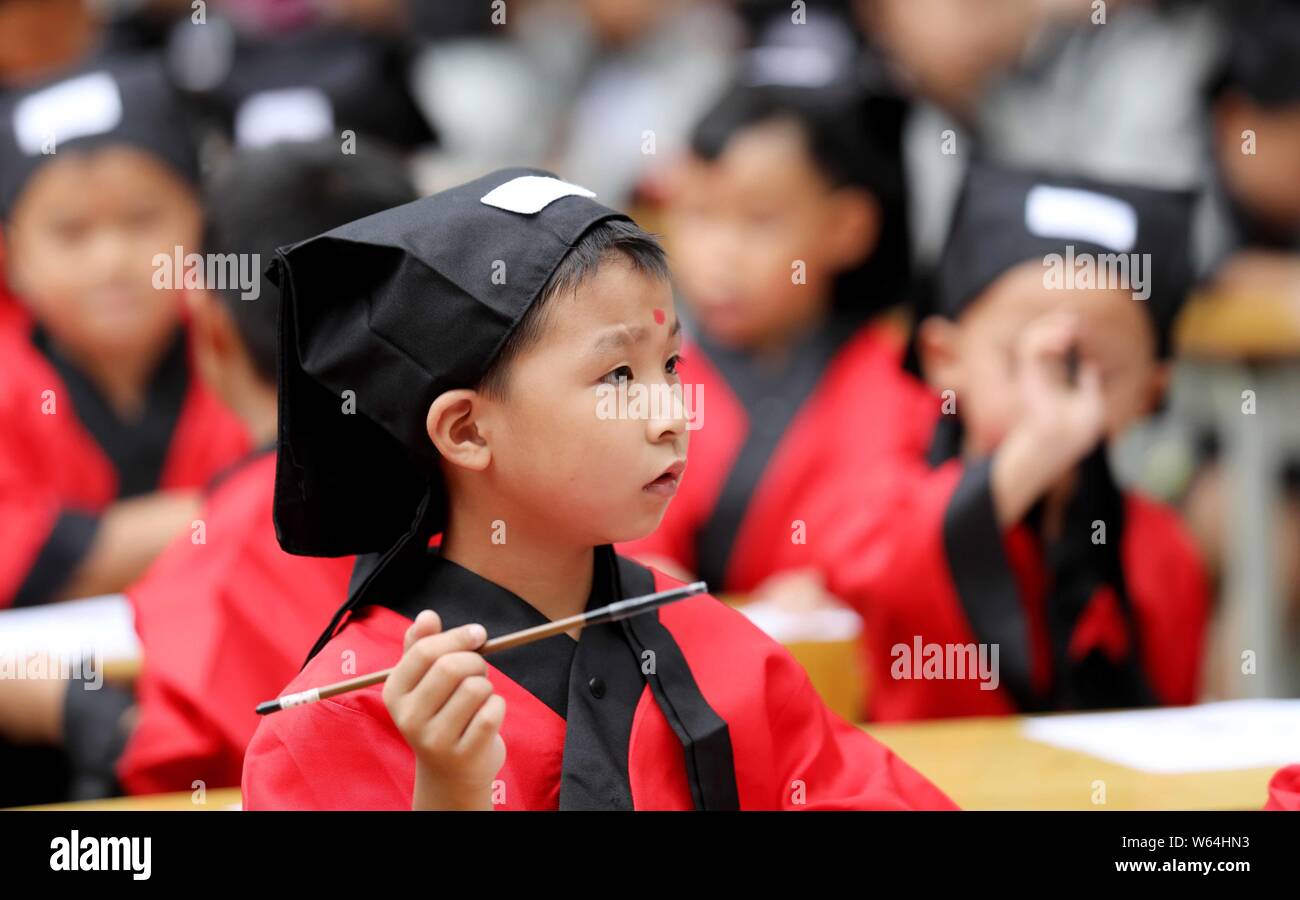 A child writes the Chinese character "ren," meaning "human" in English ...