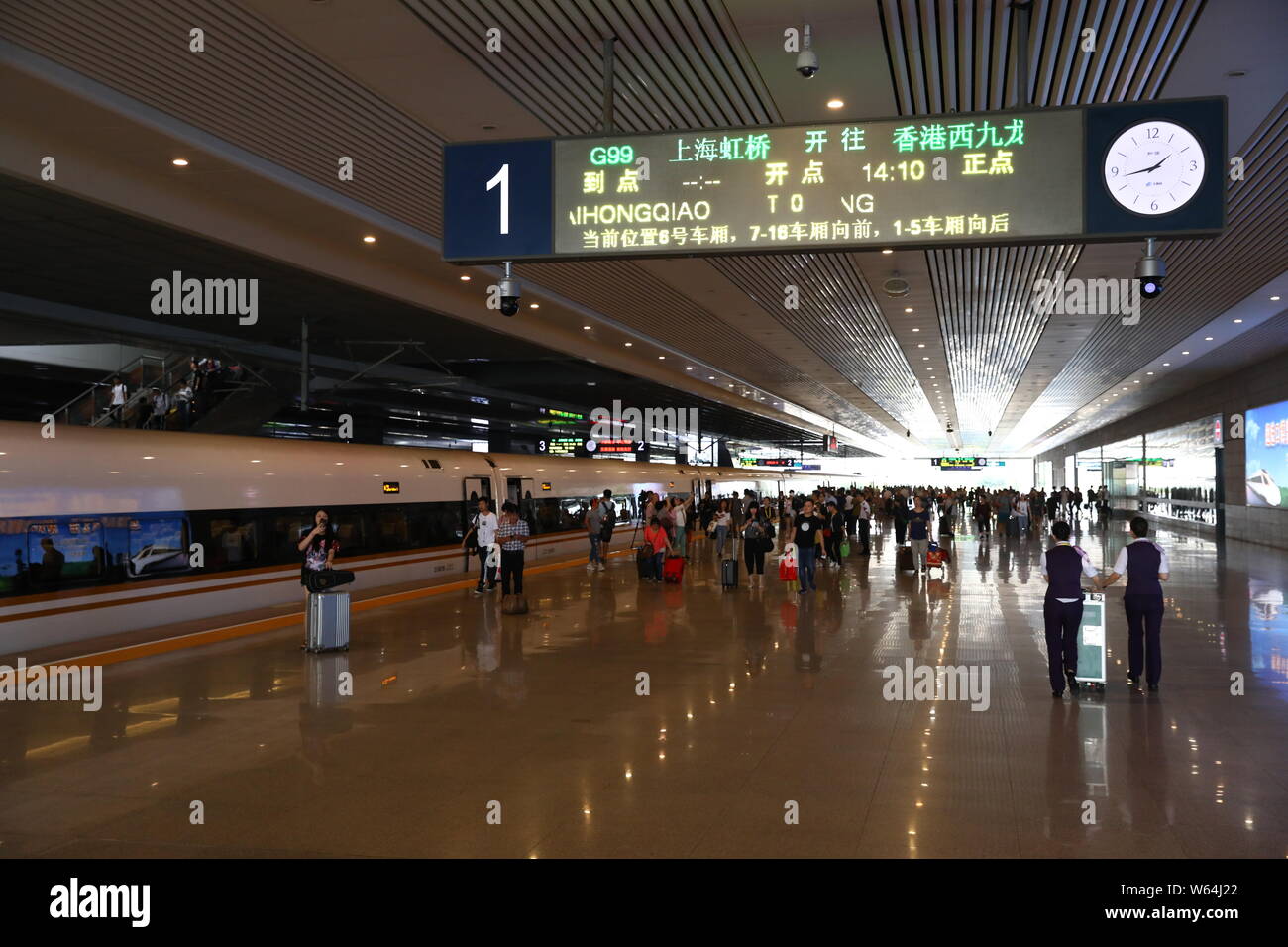 Passengers walk to board train G99, the first high-speed train from ...