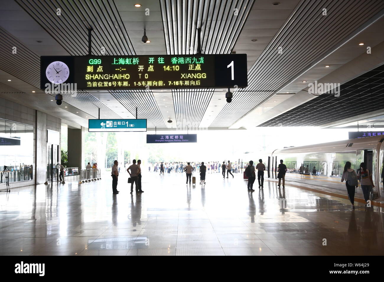 Passengers walk to board train G99, the first high-speed train from ...