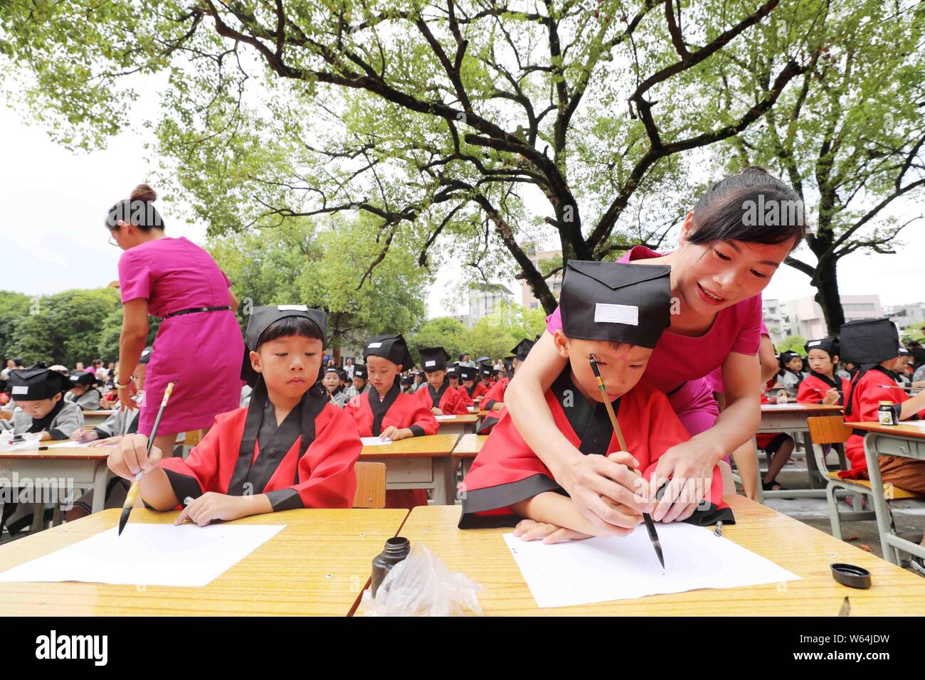 Children write the Chinese character "ren," meaning "human" in English ...