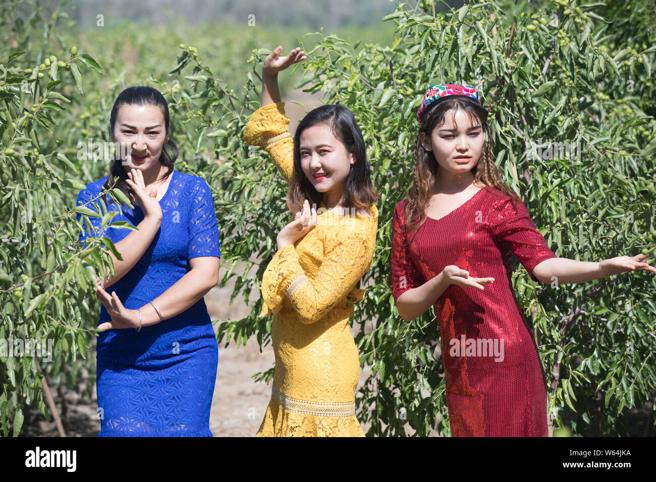 Three Uygur girls pose for photos to promote winter jujube harvests ...