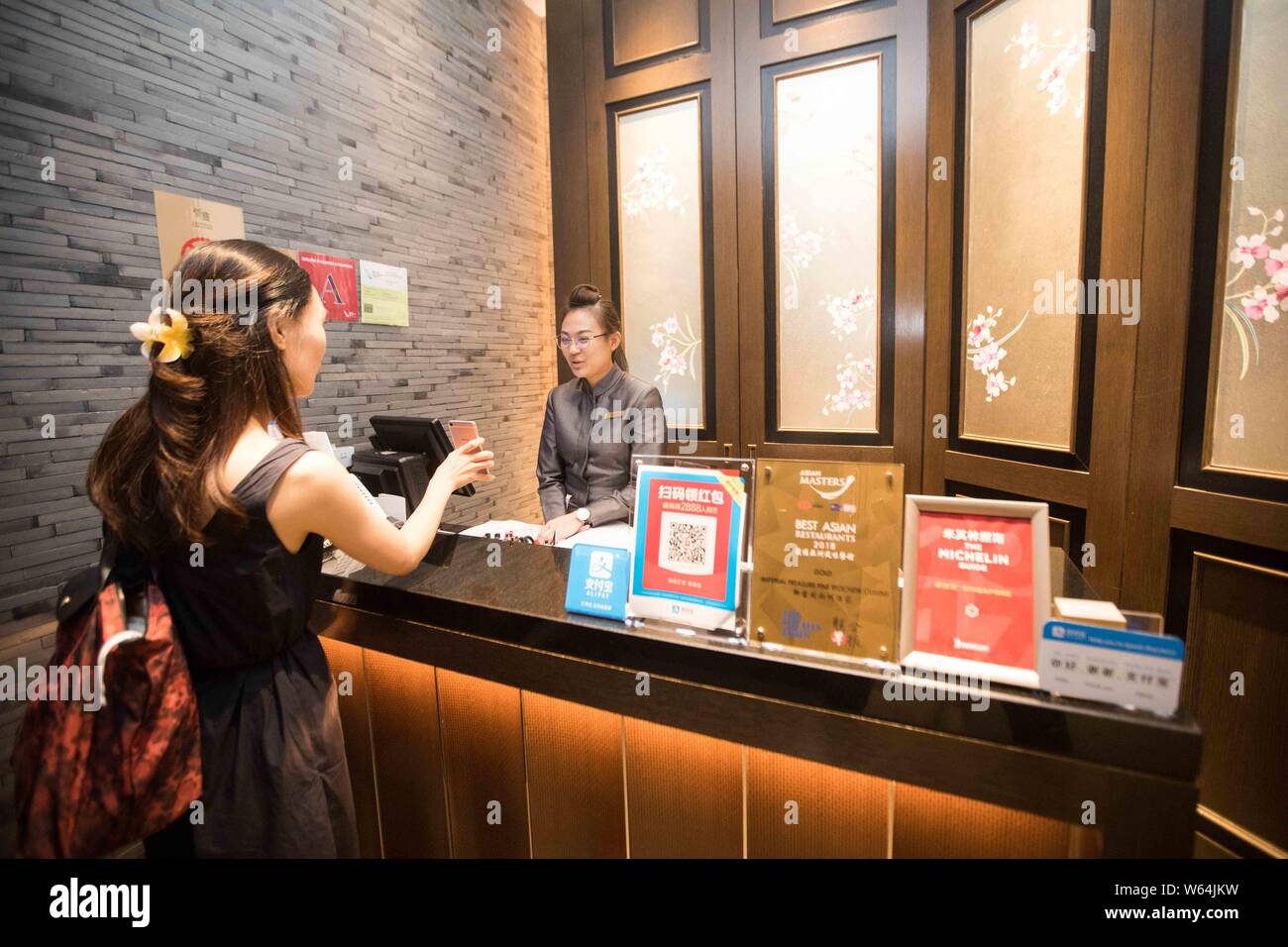 A Chinese customer have the QR code on her smartphone scanned via ...