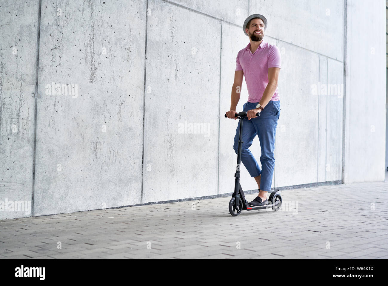 Happy man riding kick scooter Stock Photo - Alamy