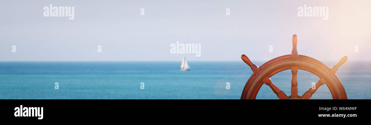 vintage nautical detail of a steering wheel of a ship in front of the ...
