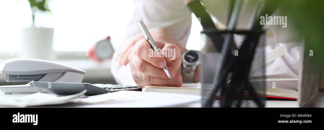 Male clerk hand holding silver pen writing something Stock Photo - Alamy