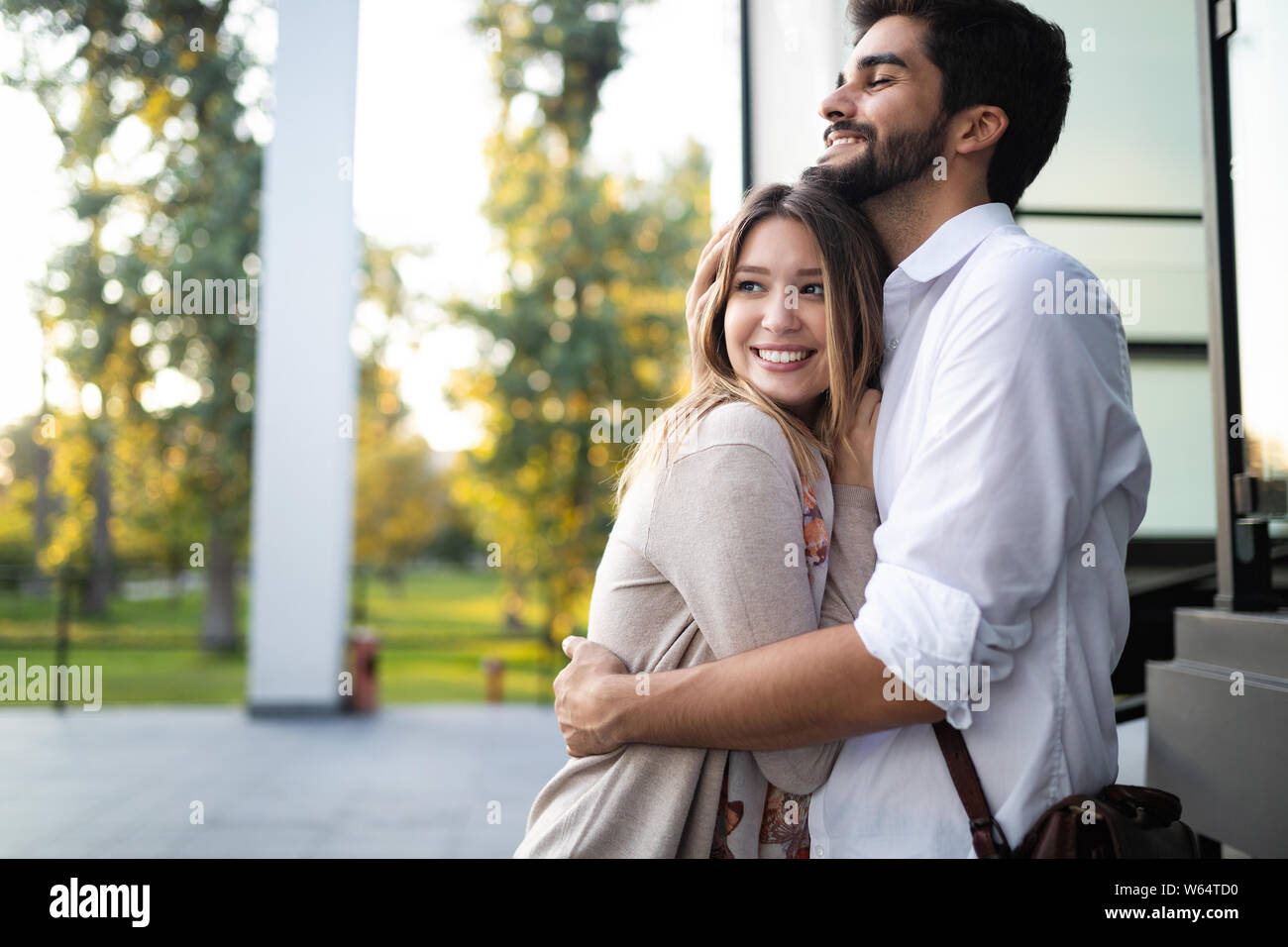 Happy young couple hugging and laughing outdoors Stock Photo - Alamy