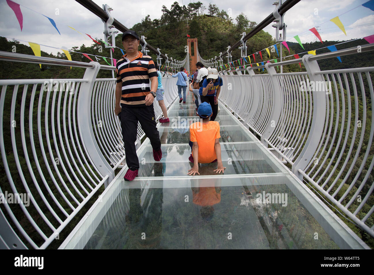 Tourists brave the 5D glass-bottom bridge over the Qinglong Valley in ...