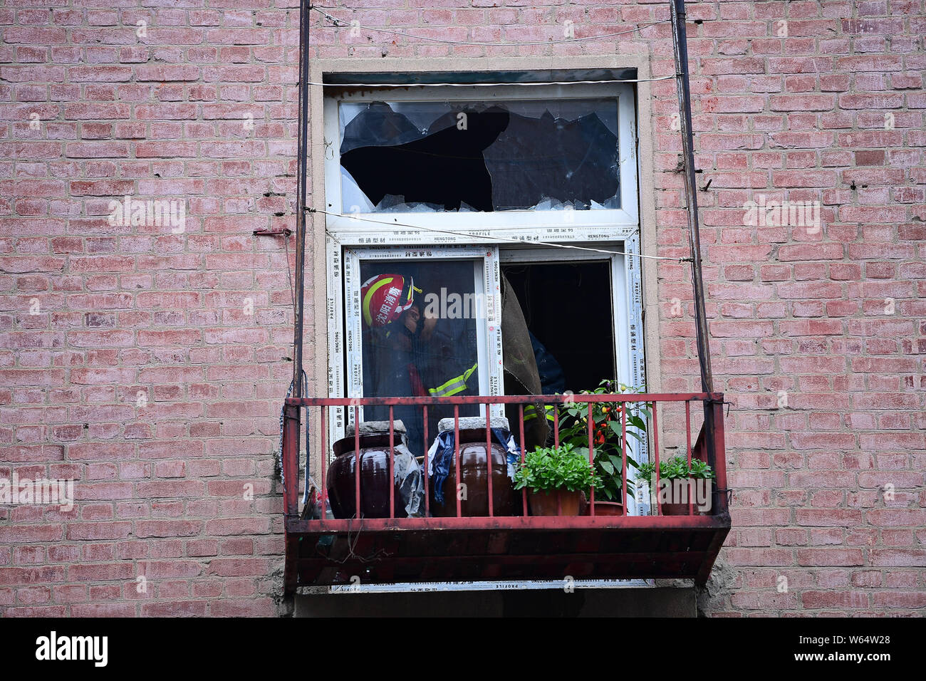 Chinese firefighters demolish a broken window after a liquefied gas ...