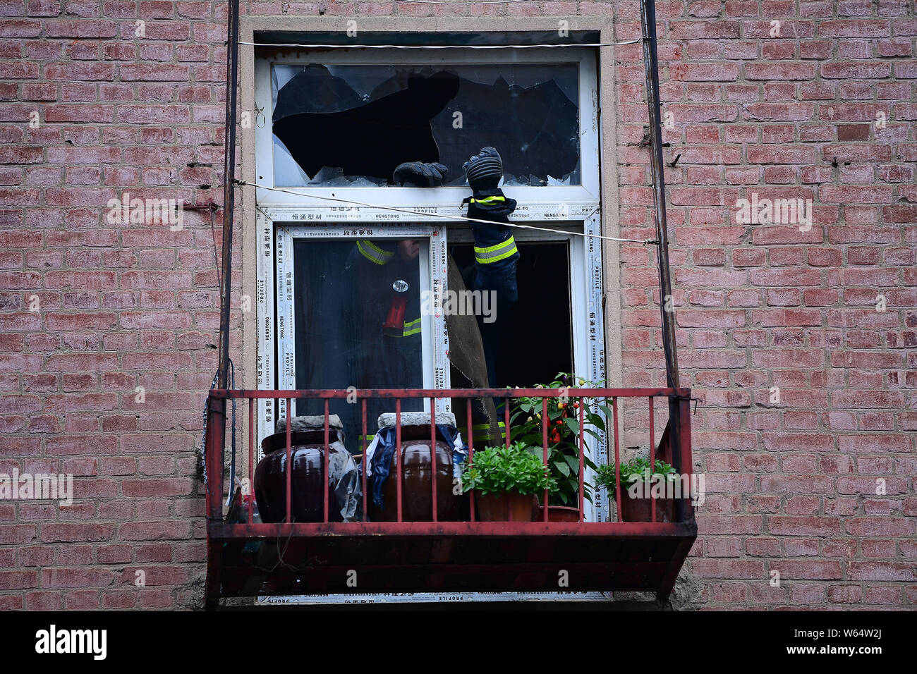 Chinese firefighters demolish a broken window after a liquefied gas ...