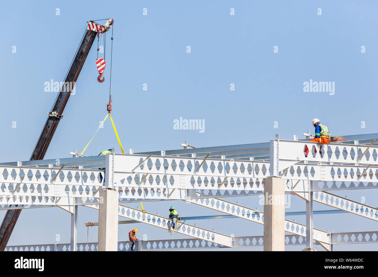 Industrial construction on site of new warehouse workers on top of high ...
