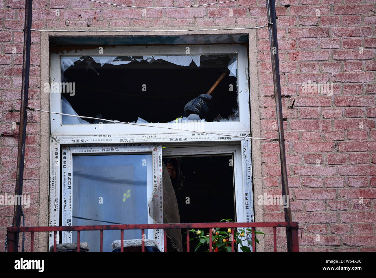 Chinese firefighters demolish a broken window after a liquefied gas ...