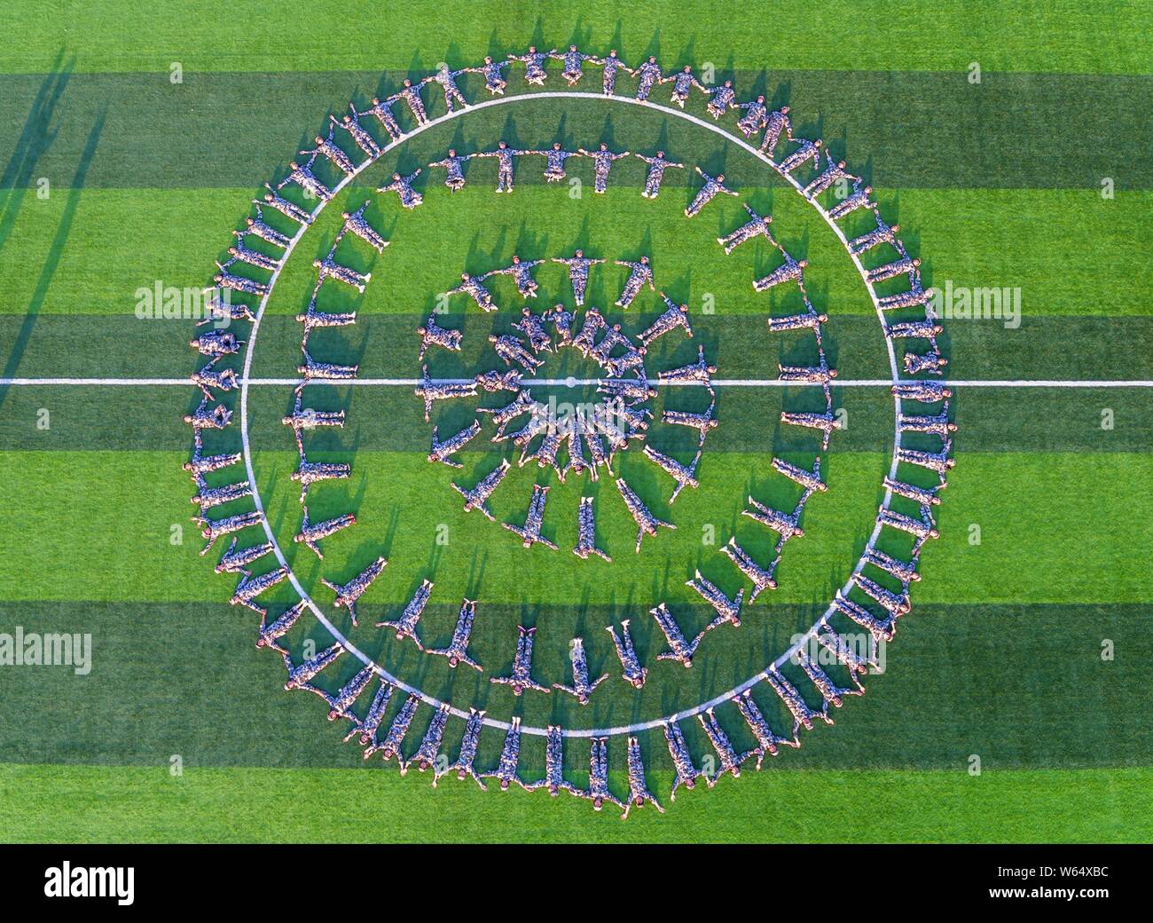 Newly enrolled high school students brave high temperatures to form a ...