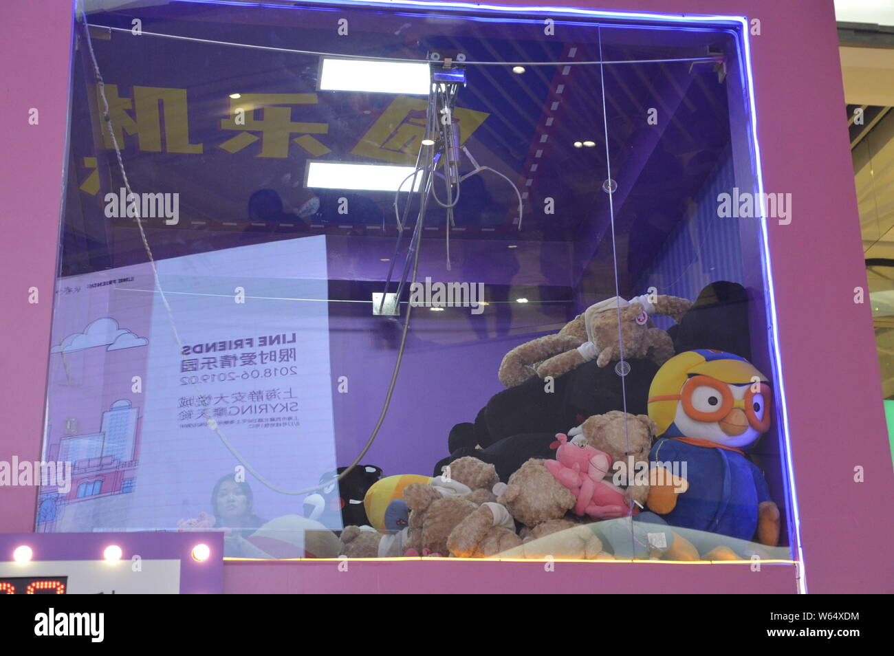 Players grab dolls inside a two-storey human doll-grabbing machine ...