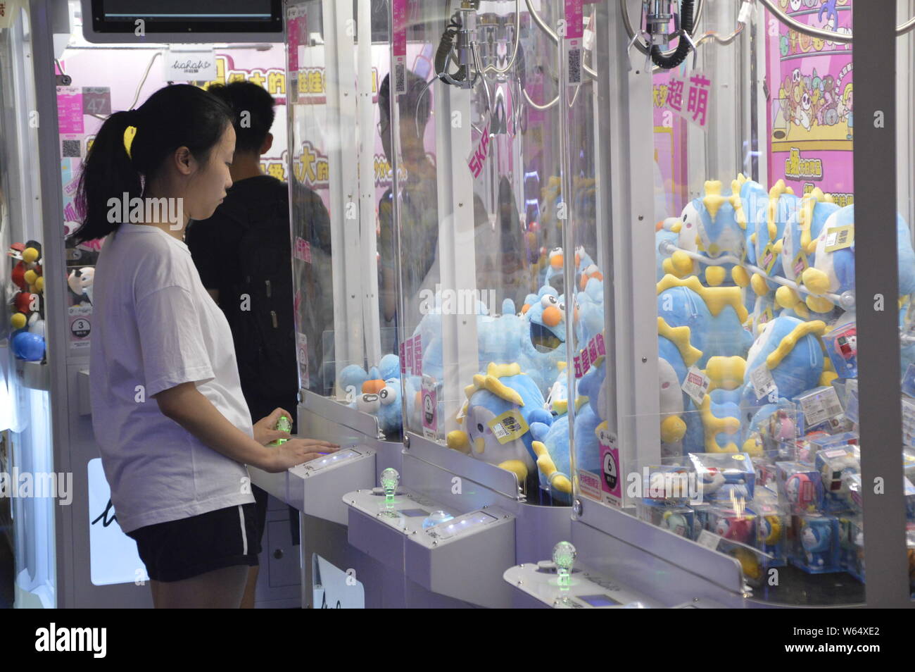 Players grab dolls on ordinary doll-grabbing machines at a shopping ...