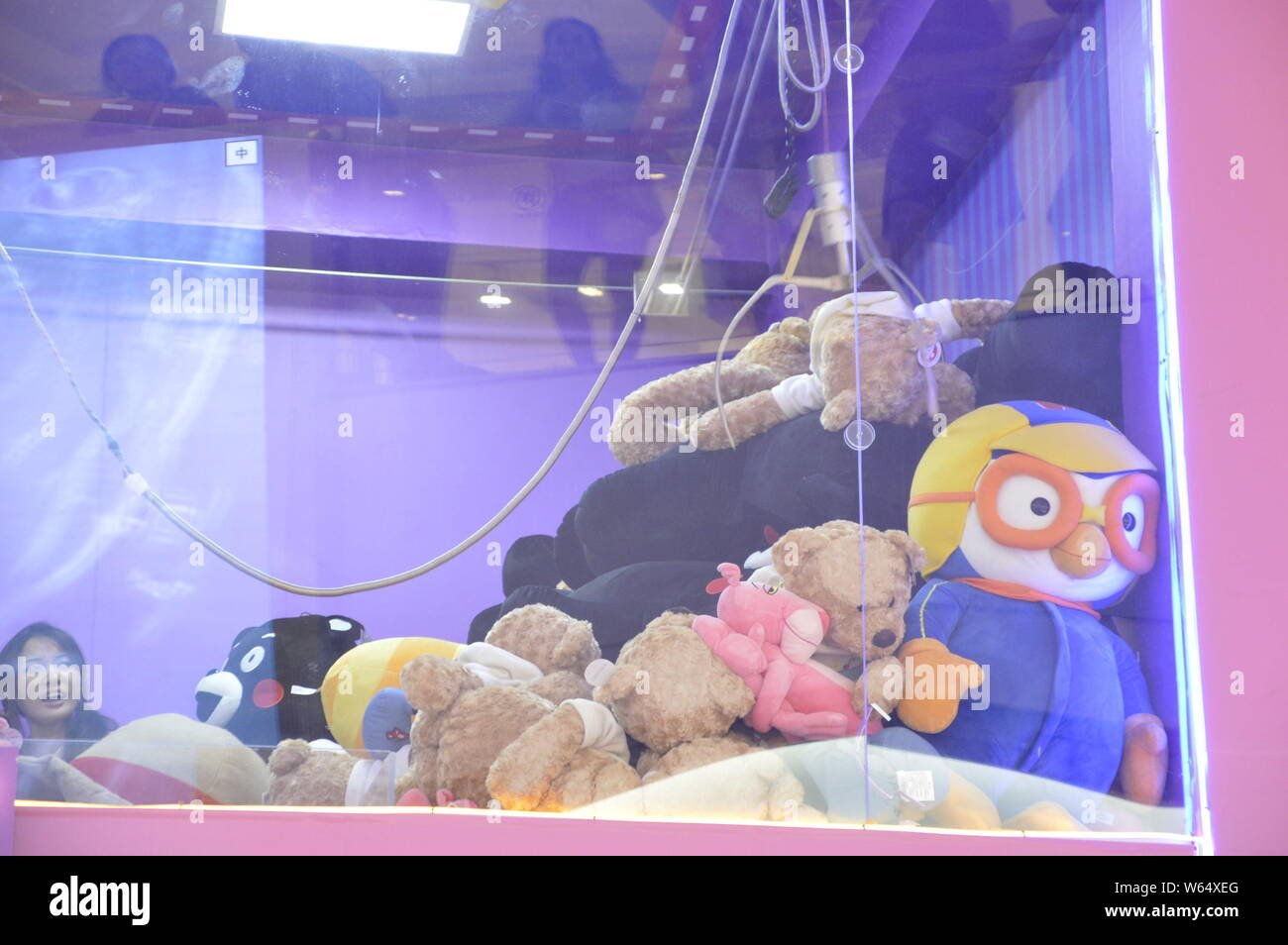 Players grab dolls inside a two-storey human doll-grabbing machine ...