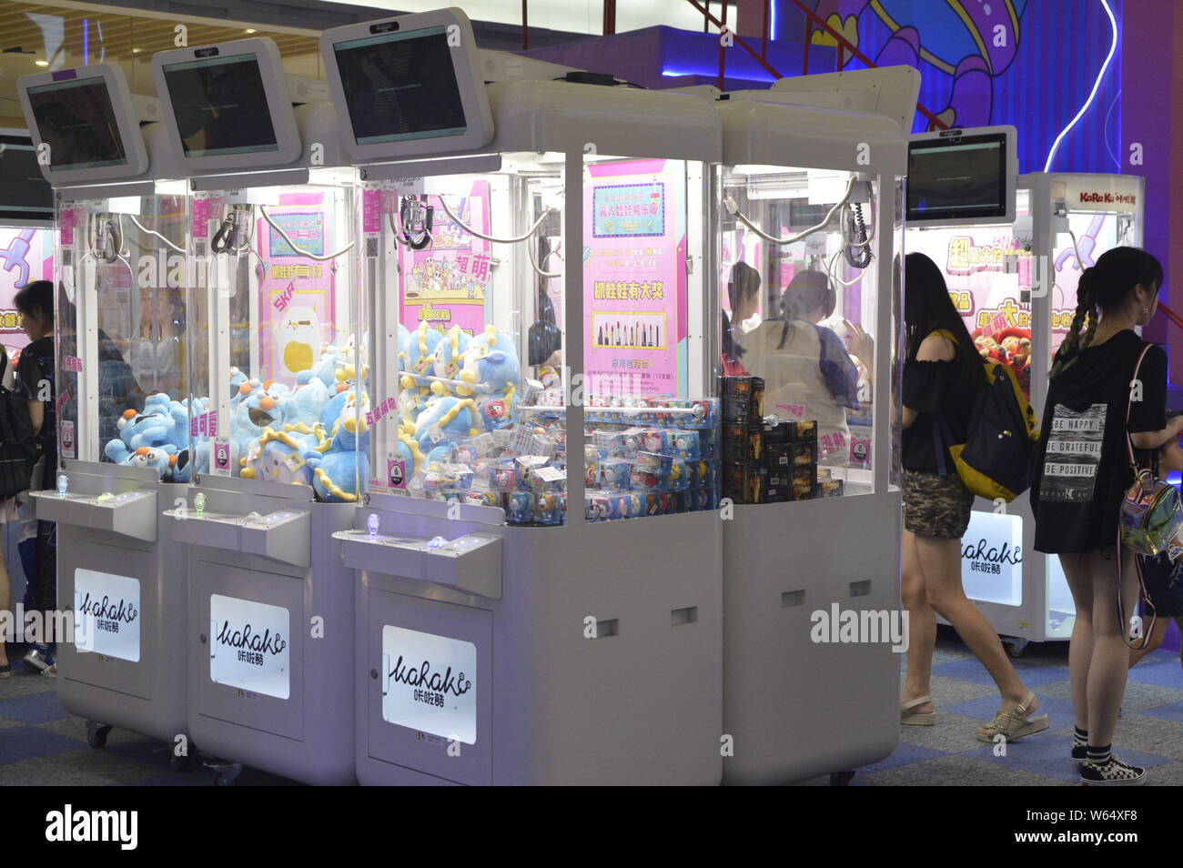 Players grab dolls on ordinary doll-grabbing machines at a shopping ...
