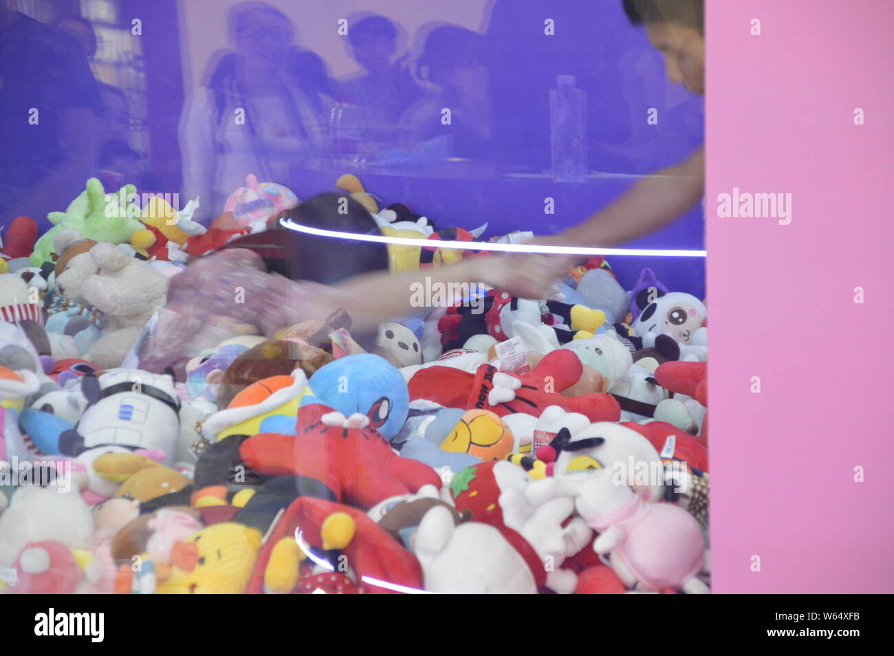 Players grab dolls inside a two-storey human doll-grabbing machine ...