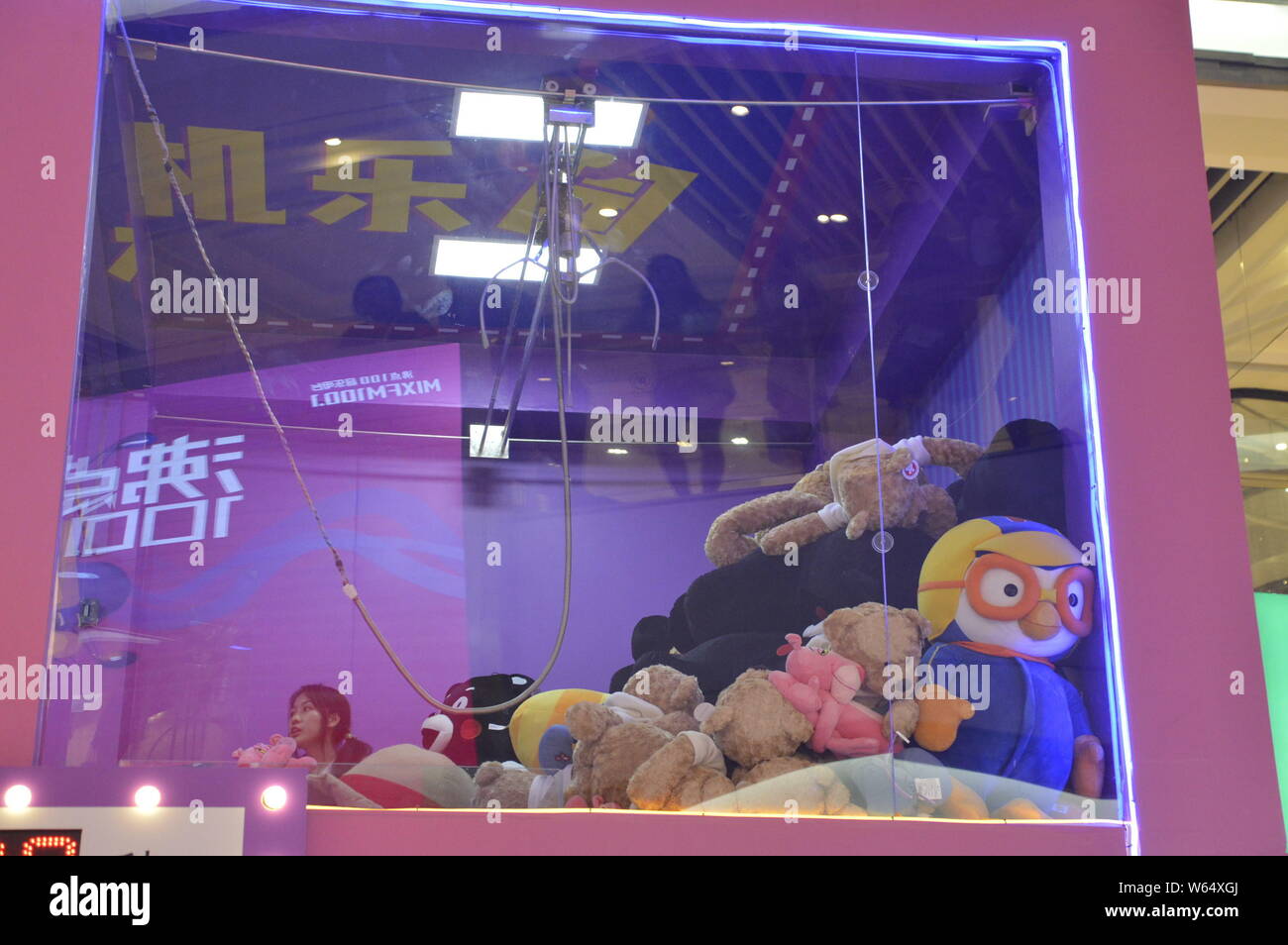 Players grab dolls inside a two-storey human doll-grabbing machine ...