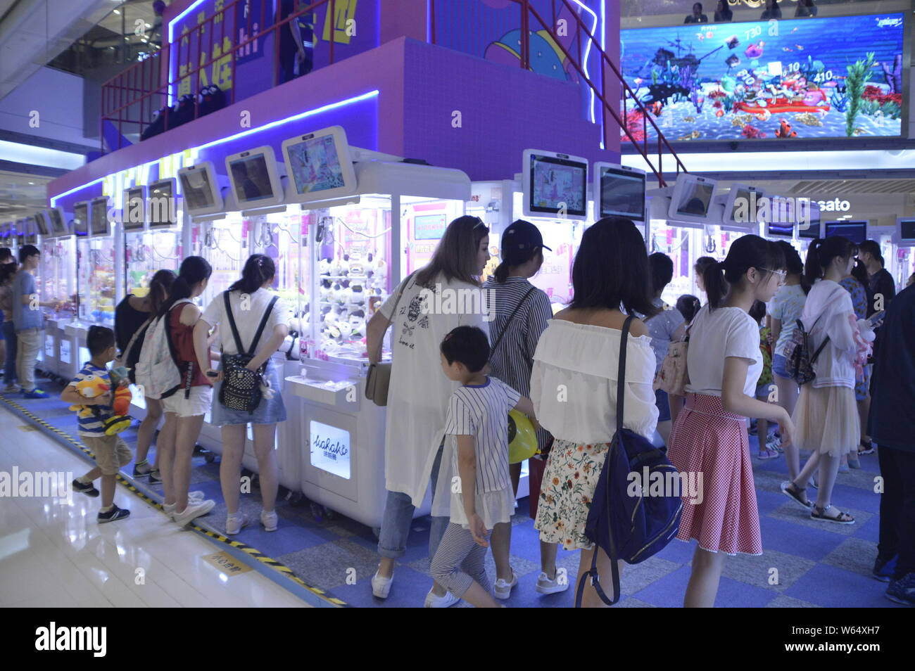 Players grab dolls on ordinary doll-grabbing machines at a shopping ...