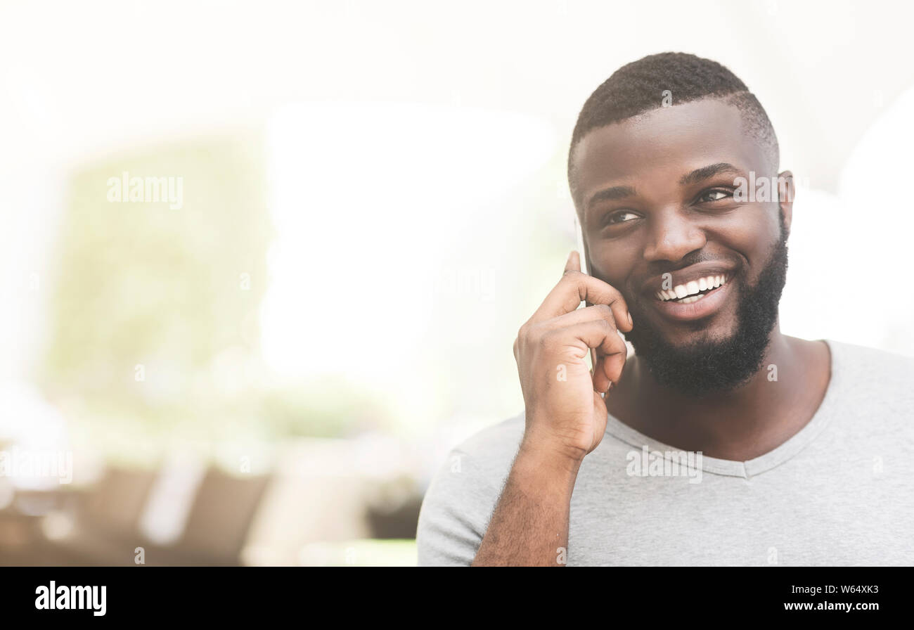 Portrait of african man speaking by phone and smiling Stock Photo - Alamy