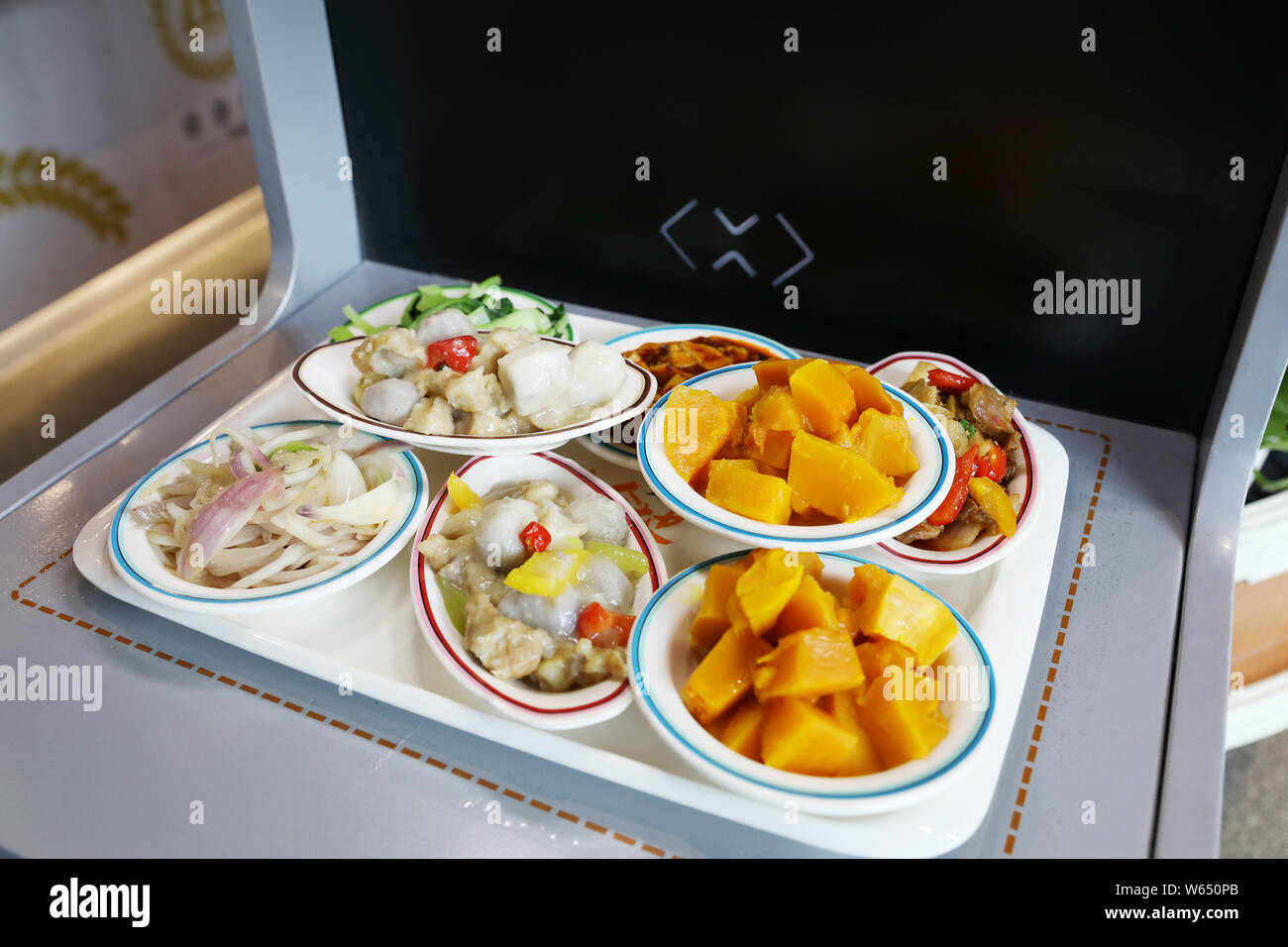 A Chinese employee puts his selects on a self-service check-out machine ...