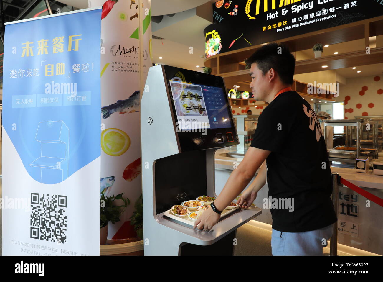 A Chinese employee puts his selects on a self-service check-out machine ...
