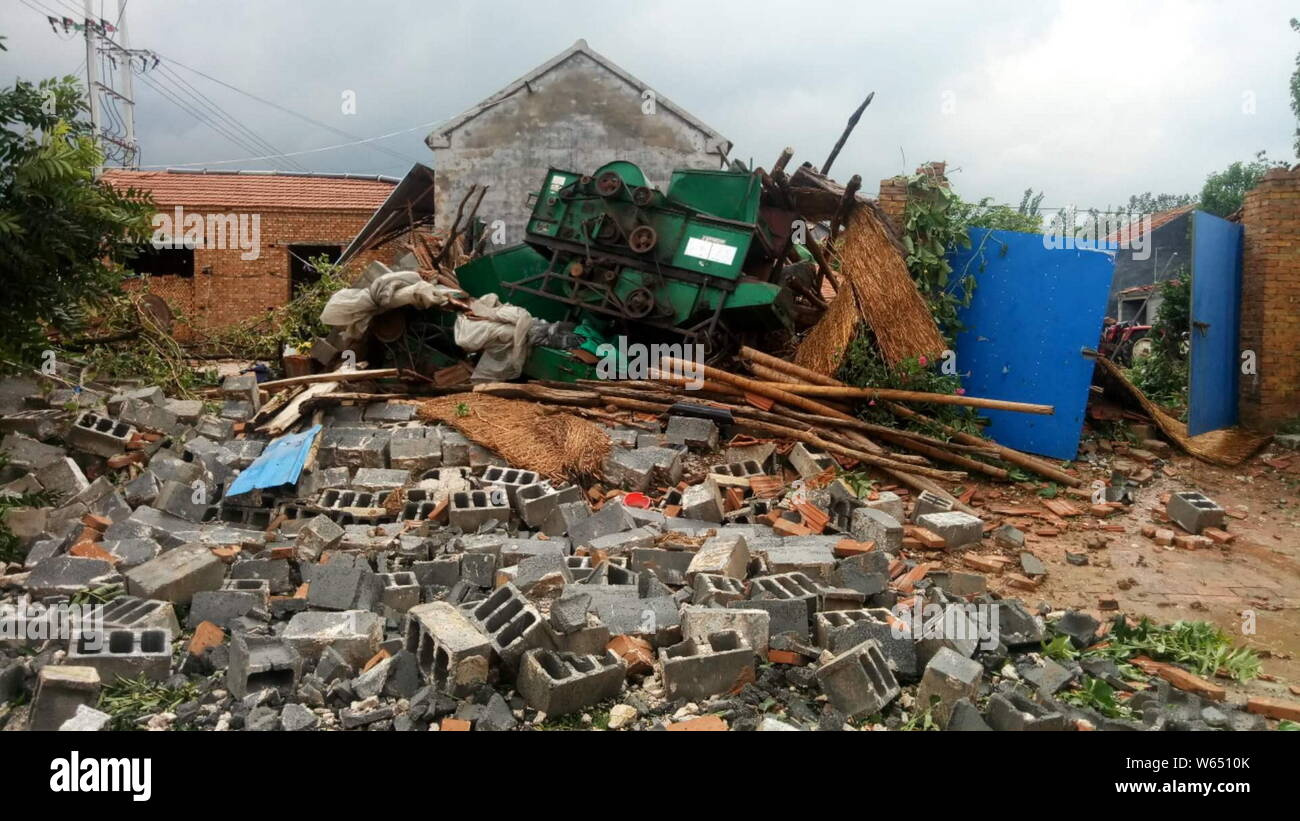 Tiles of the rooftop of a residential house are damaged by strong wind ...