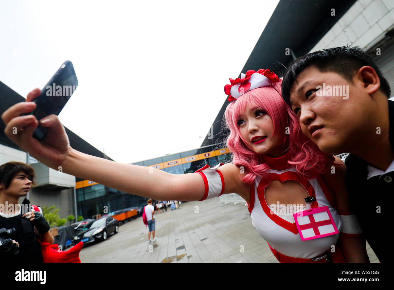 A Chinese Showgirl Dressed In Cosplay Costume Takes A Selfie With A Visitor During The 16th