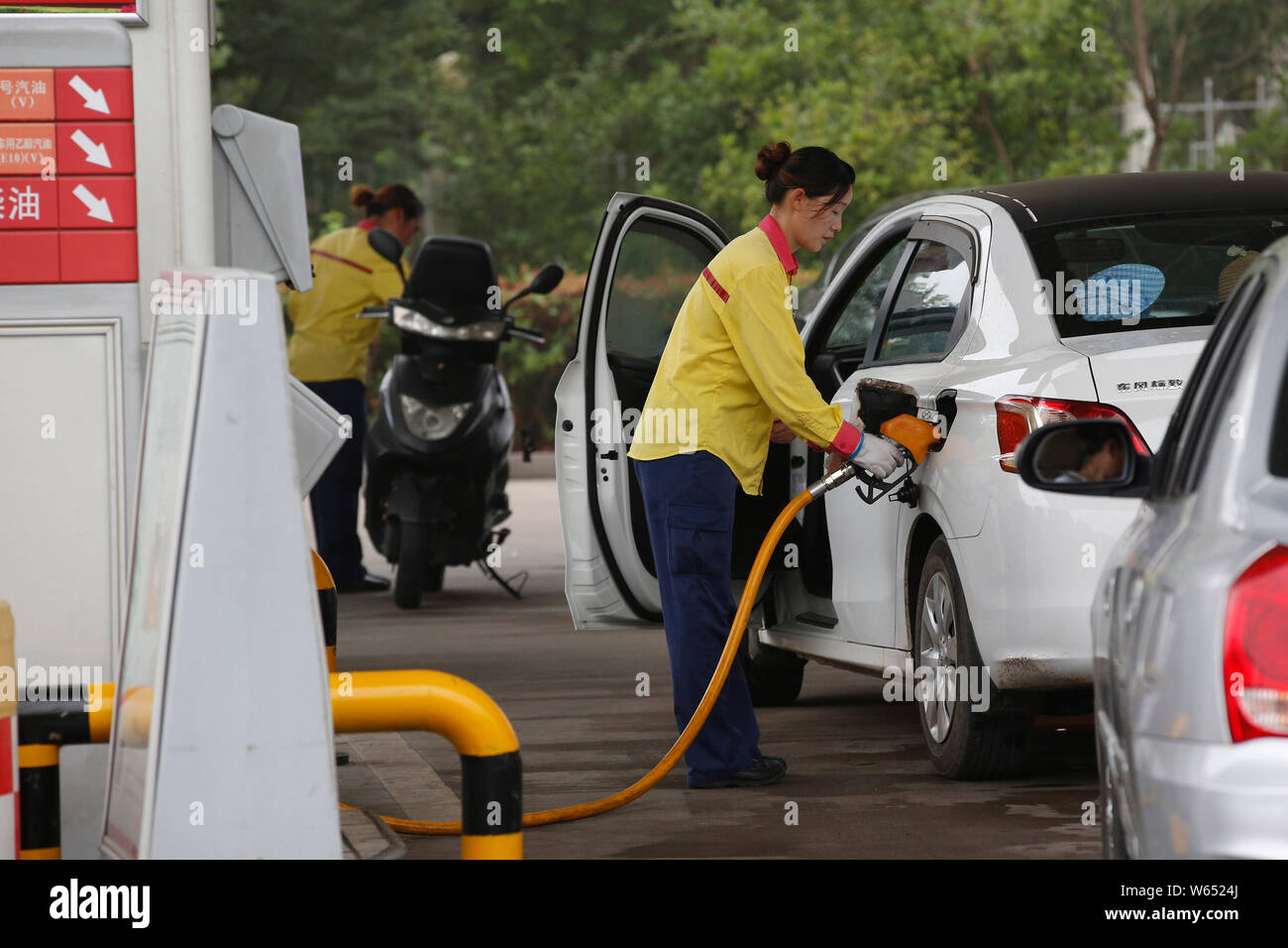--FILE--A Chinese worker refuels a car at a gas station of CNPC (China ...