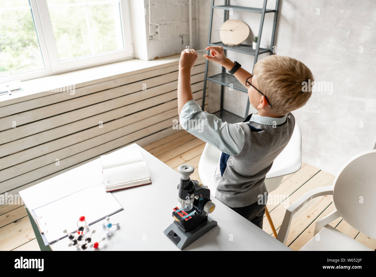 Young boy preparing samples for examination under microscope Stock ...