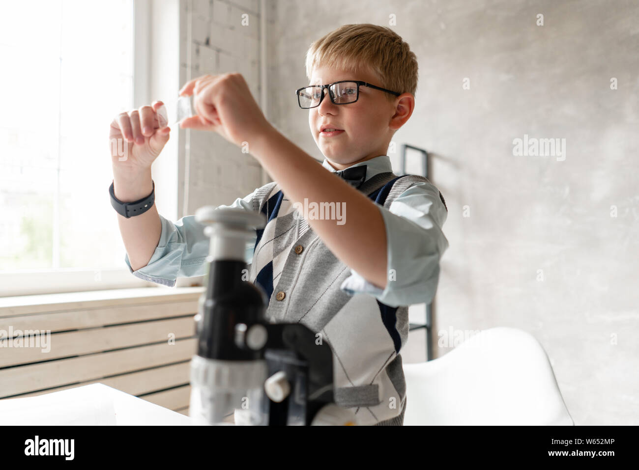 Young boy preparing samples for examination under microscope Stock ...