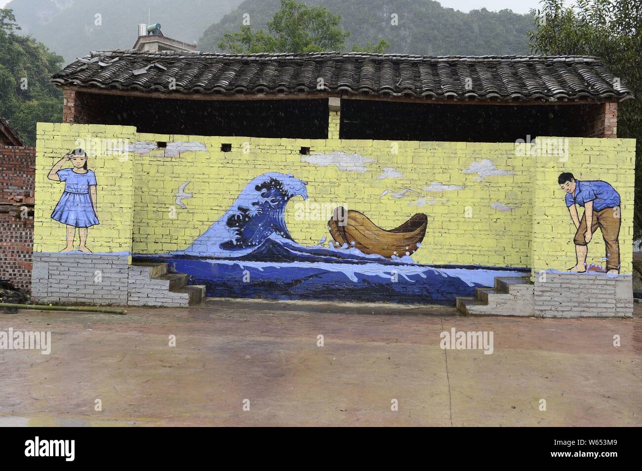 A colored drawing is seen on a wall in Heye village, Babao town ...