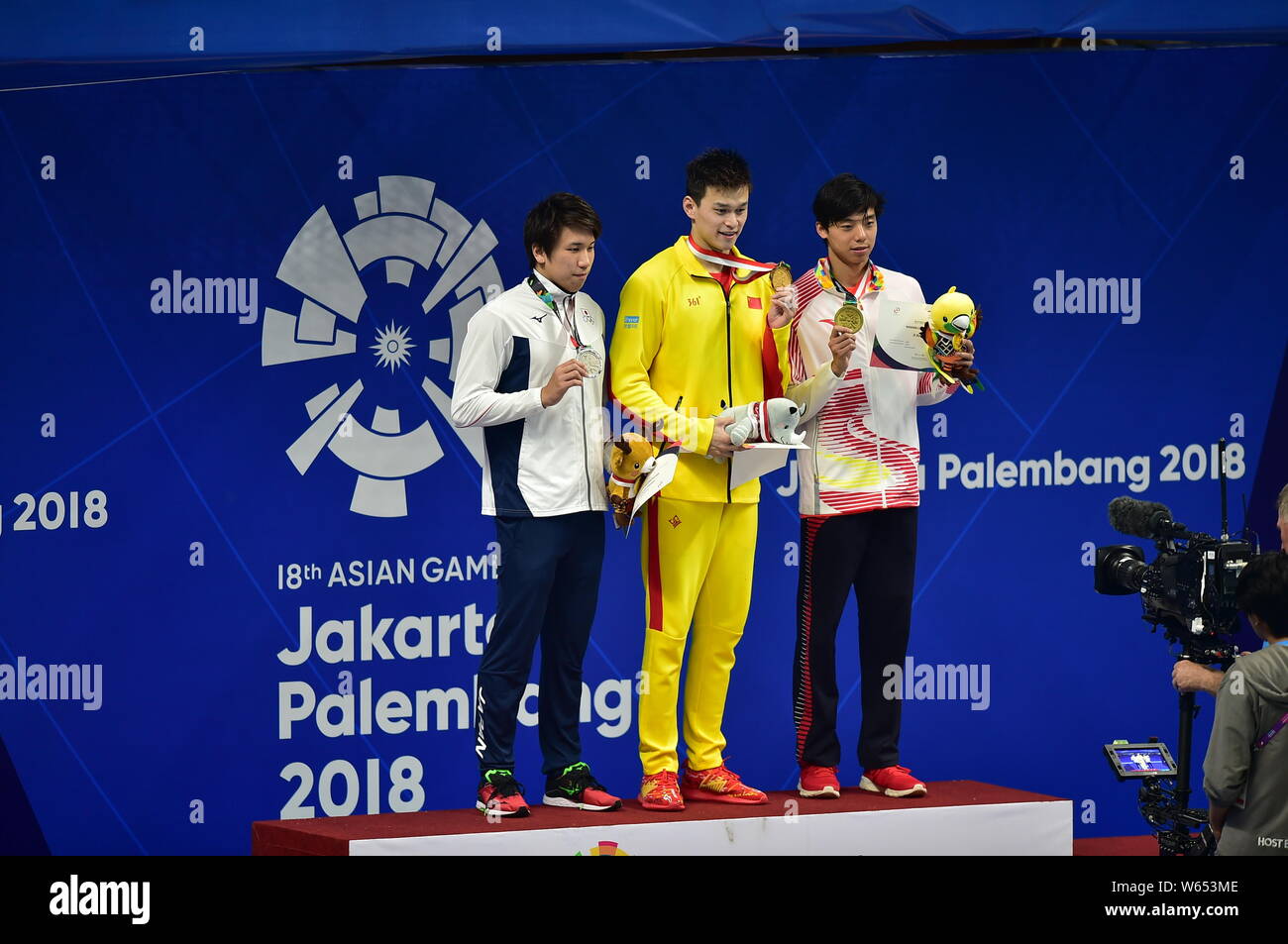 Gold medalist China's Sun Yang, center, poses with his trophy between ...