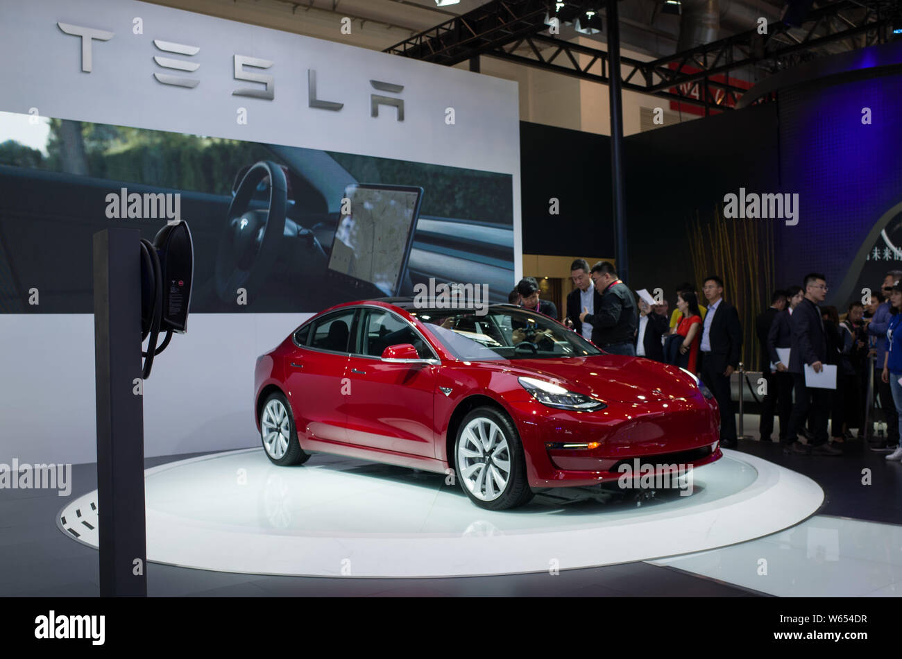 --FILE--People look at a Tesla Model 3 car on display during the 15th ...