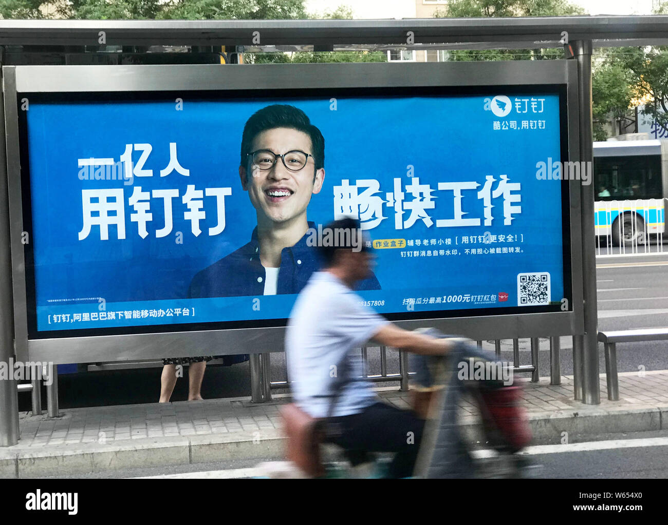 --FILE--A cyclist rides past an advertisement for DingTalk, the ... --FILE--A cyclist rides past an advertisement for DingTalk, the ...