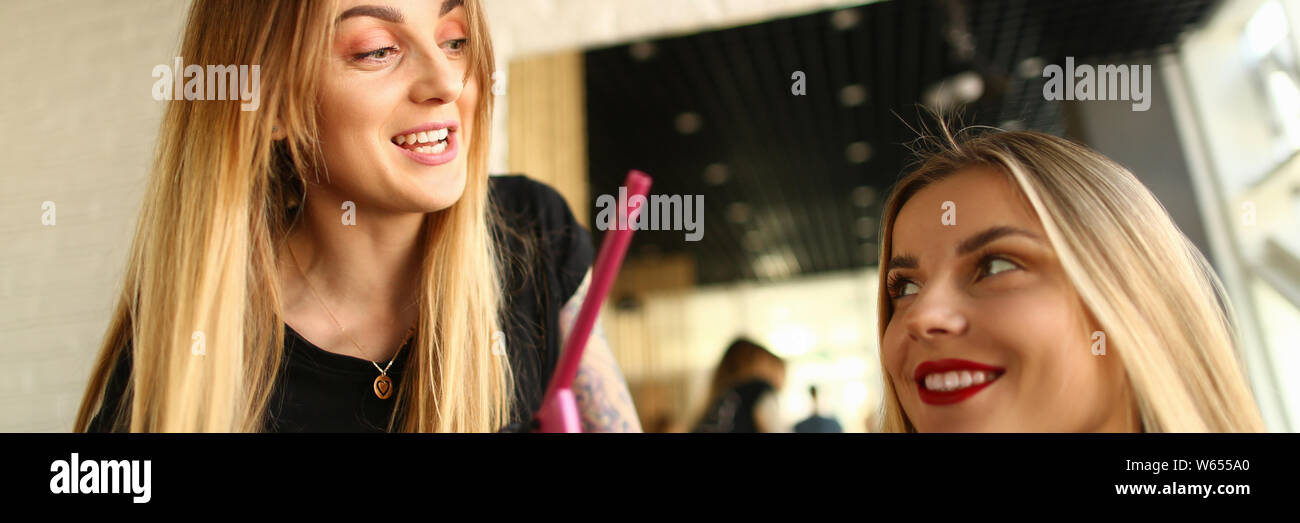Happy Hairdresser Showing Curling Iron to Client Stock Photo - Alamy Happy Hairdresser Showing Curling Iron to Client Stock Photo - Alamy