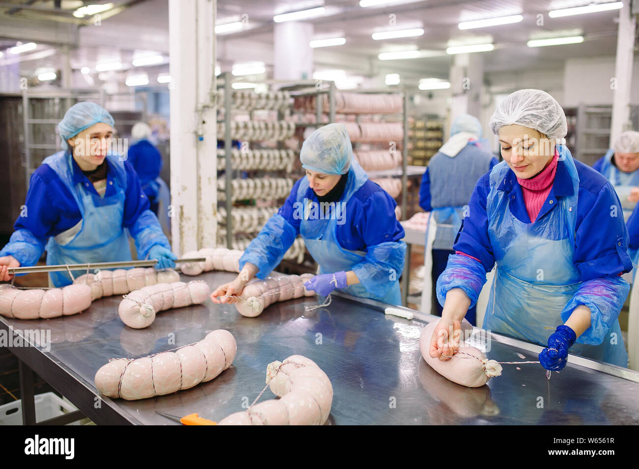 Butchers processing sausages at the meat factory Stock Photo - Alamy
